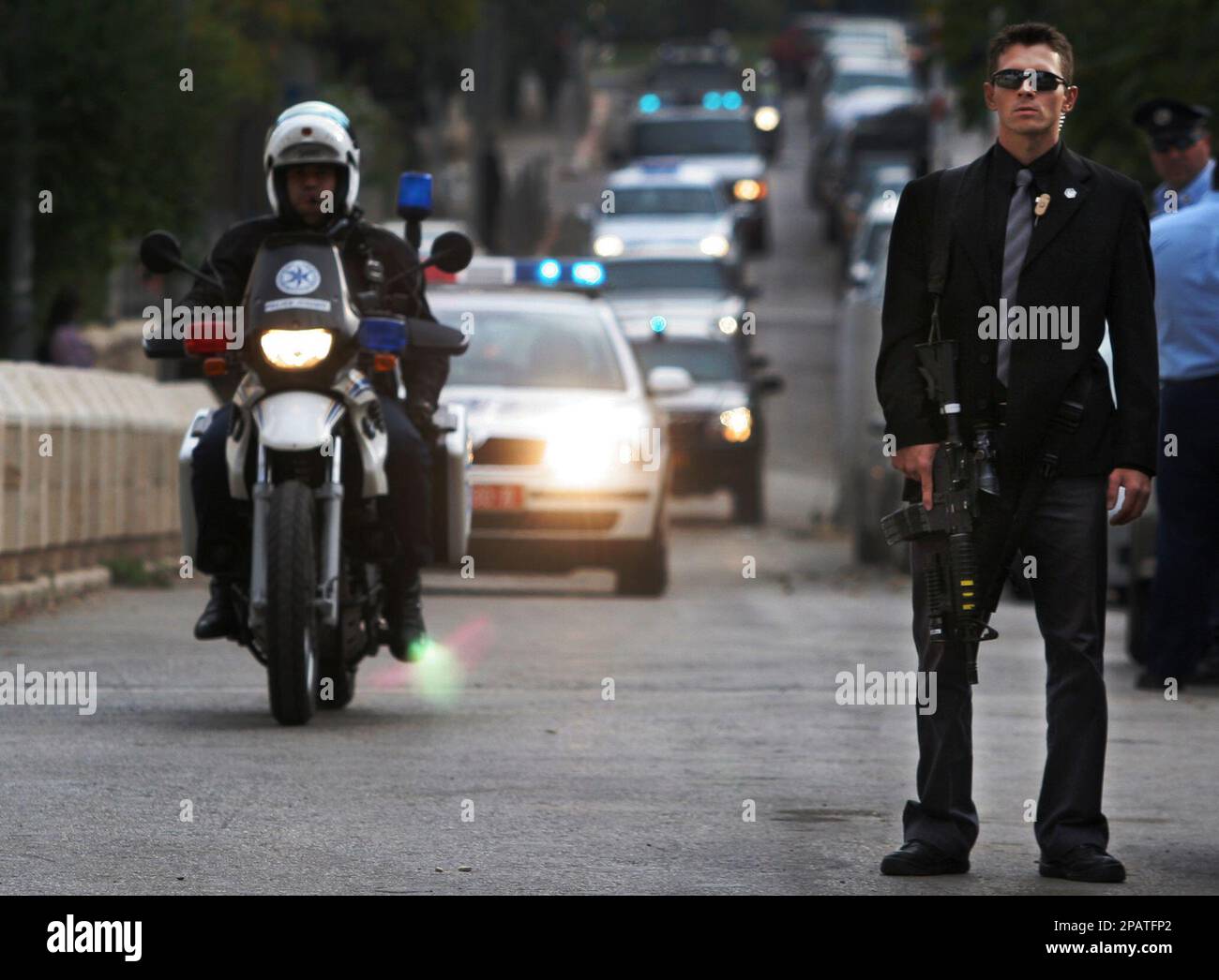 An Israeli security guard stands in the street as the convoy of ...
