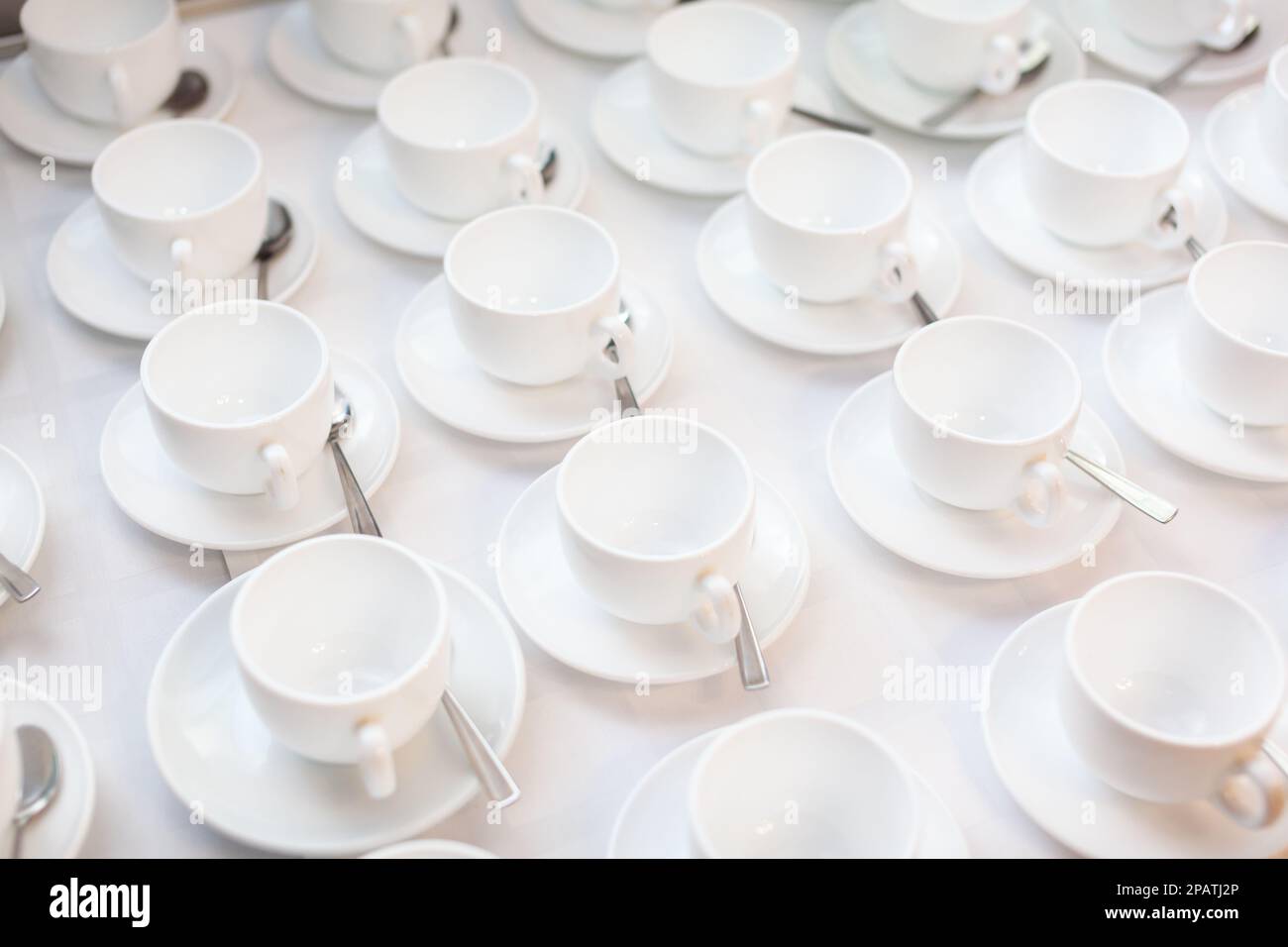 Many rows of white ceramic coffee or tea cups. Lines of coffee cups in ...