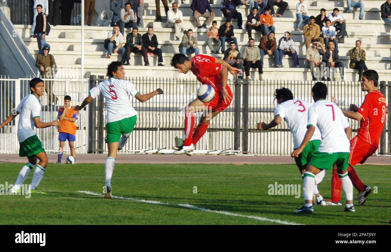 Syrian players, in red, and Indonesian players contest a crossed ball ...