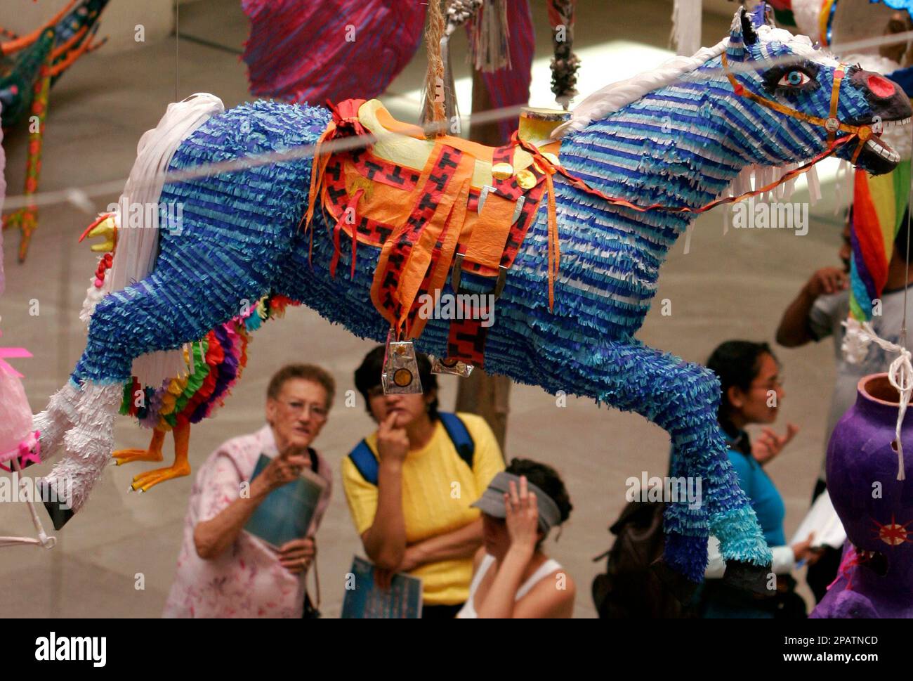 People look at pinatas competing in Mexico's first pinata competition ...
