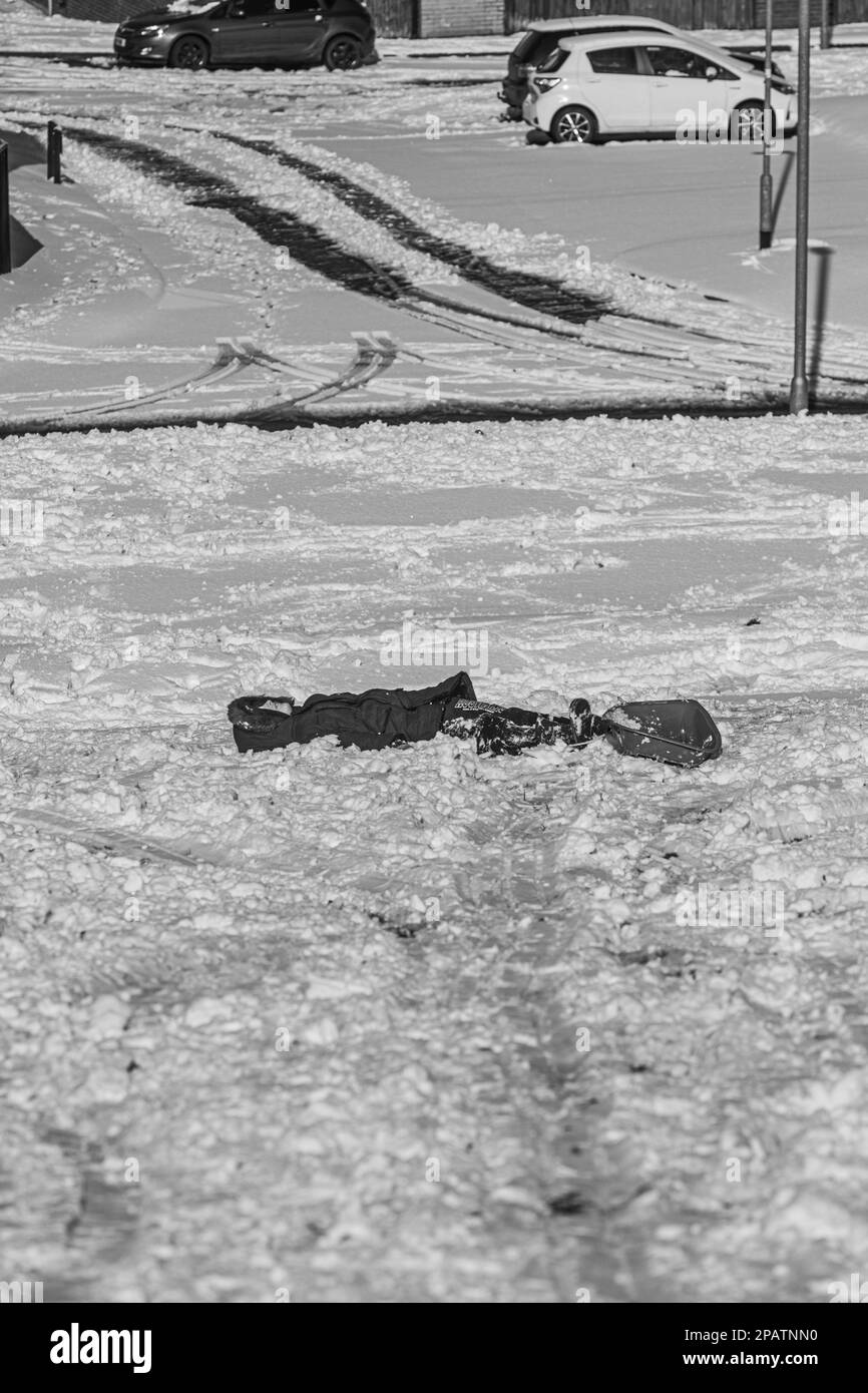 A boy laying down in the snow on a hill Stock Photo - Alamy