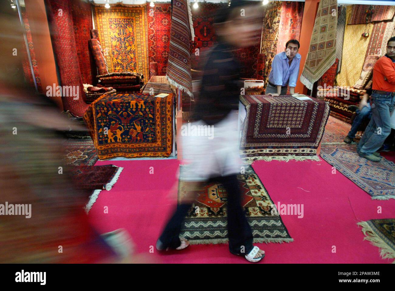 Visitors walk past an Afghanistan carpet stall at the 27th India ...