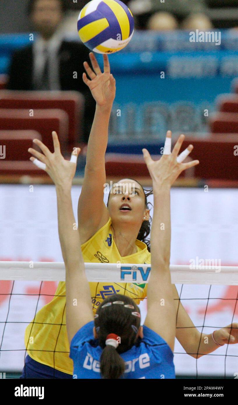 Brazilian Sheilla Castro, facing camera, spikes the ball against ...