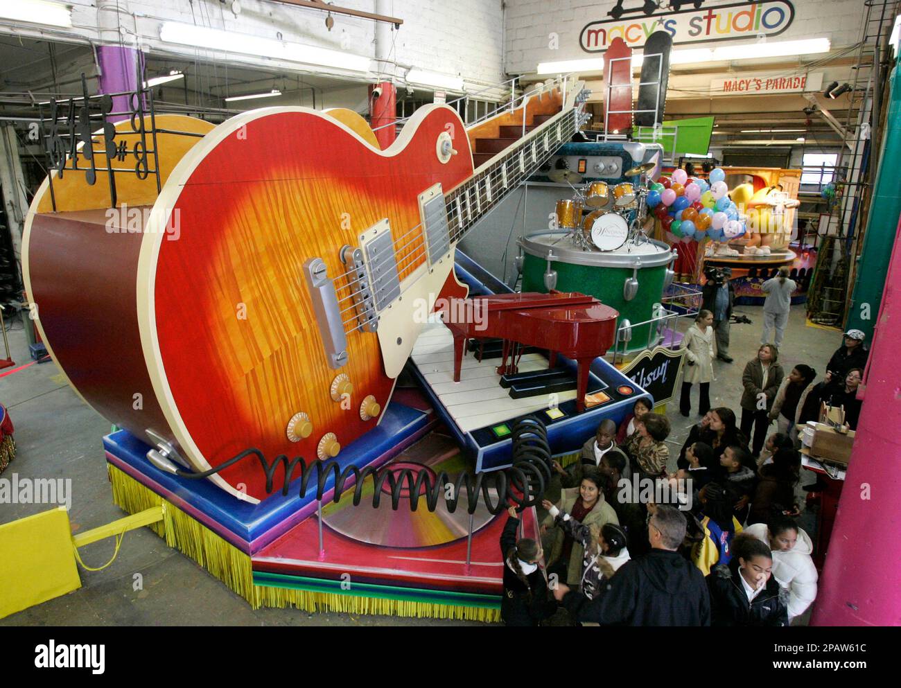 Grade school students walk past a giant electric guitar on the Music ...