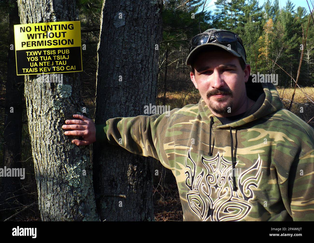 Eric Humbert leans on a tree beside his new "No Hunting" sign printed ...