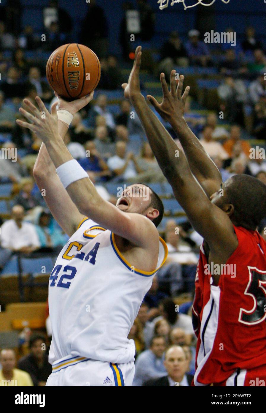 UCLA's Kevin Love (42) drives pass Youngstown State's Jack Liles, right ...