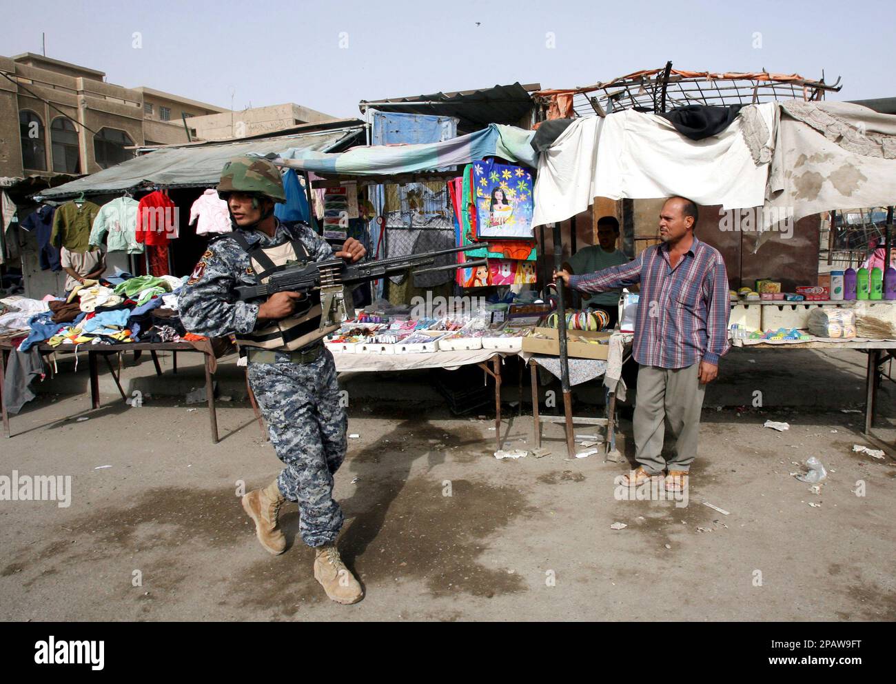 An Iraqi policeman walks in a market while patrolling the streets of ...
