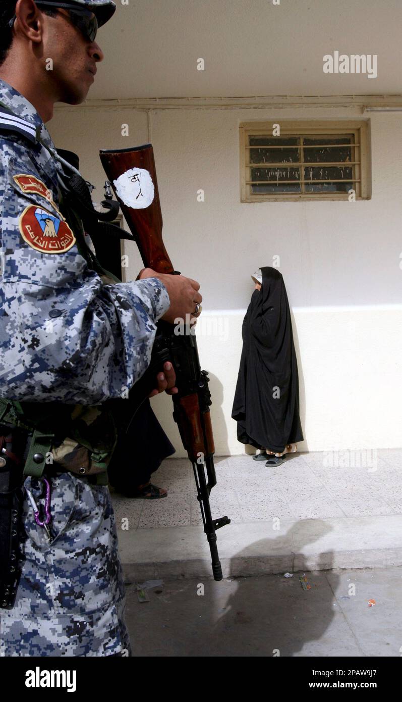 An Iraqi police officer patrols a street in south Baghdad's Dora ...