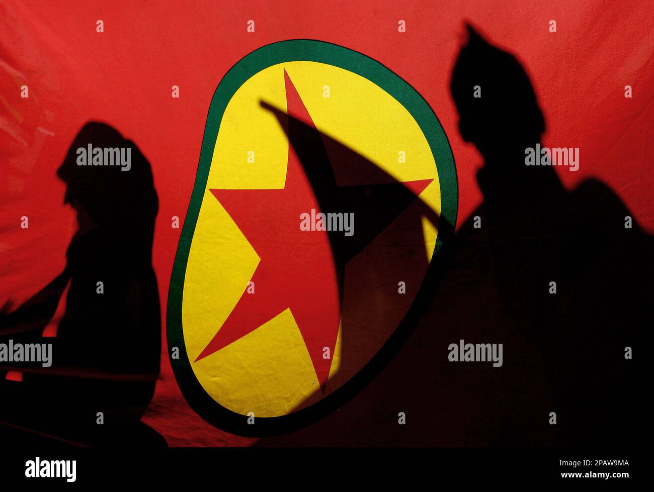 Kurdish demonstrators are silhouetted by a Kurdistan Workers' Party ...