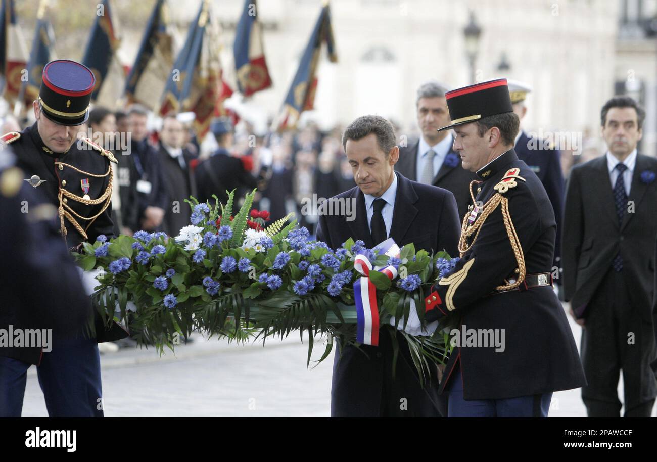 French President Nicolas Sarkozy, center, lays a wreath on the unknown ...