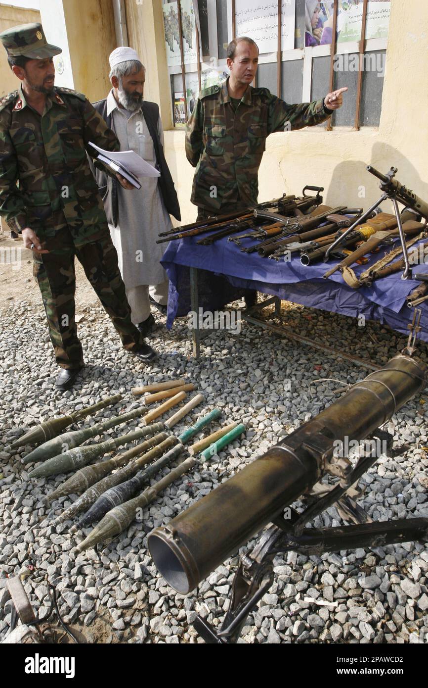 Afghan military officers arrange weapons and ammunition during a ...