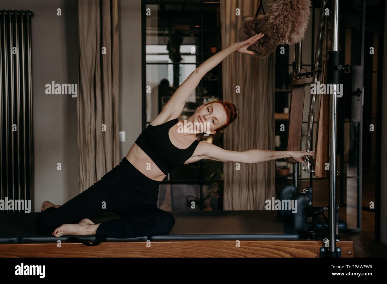 Attractive fit red haired woman with perfect body shape exercising and ...