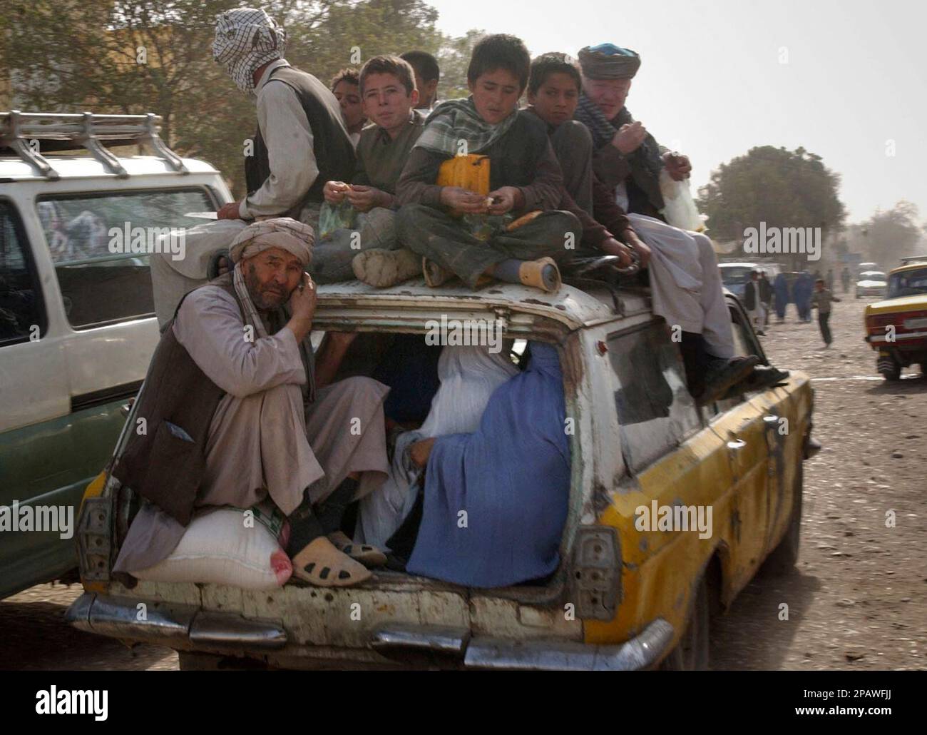 Afghan passengers are seen transported by a taxi vehicle in Mazar-e ...