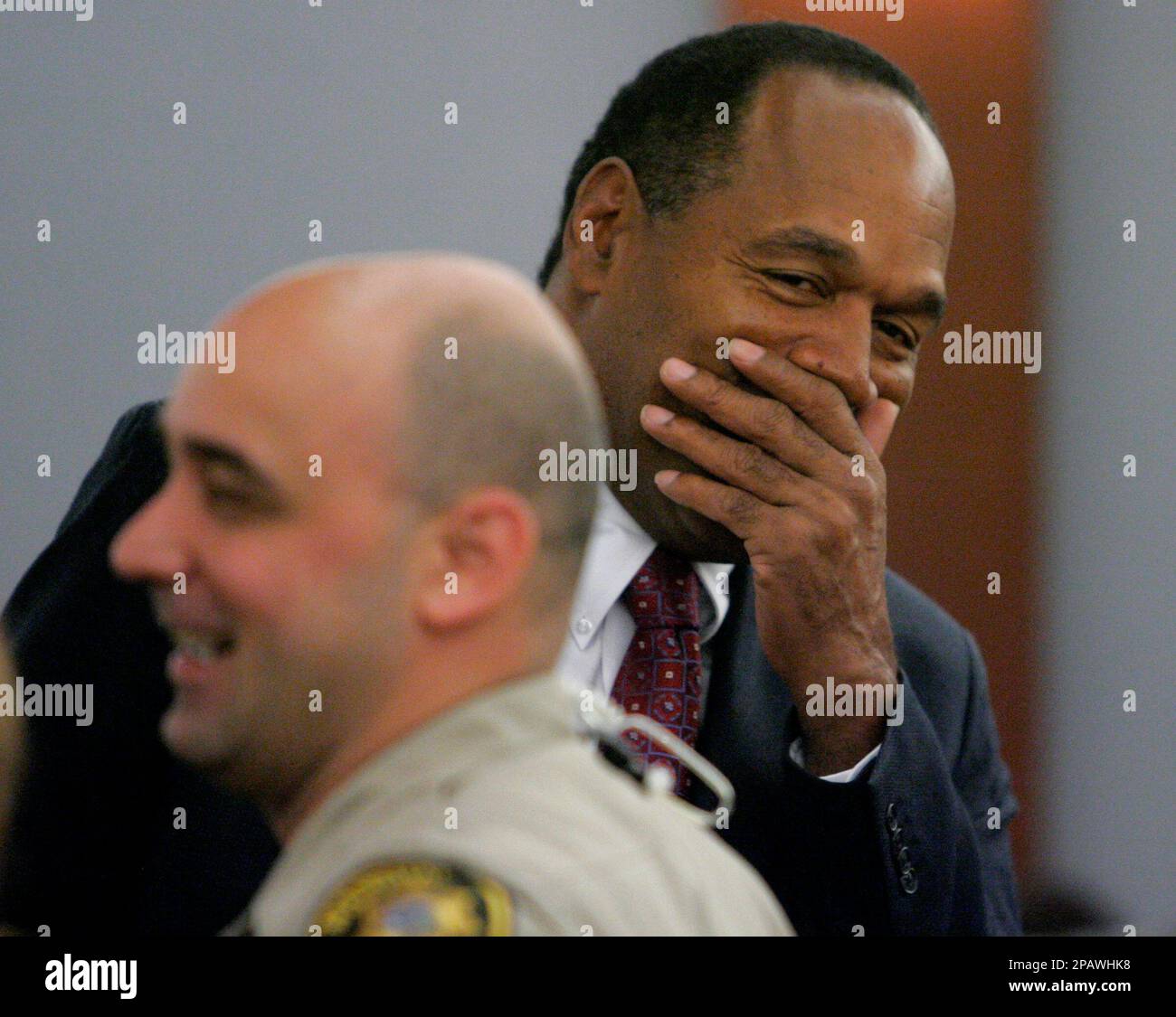 O.J. Simpson laughs as he appears in a courtroom for his preliminary ...