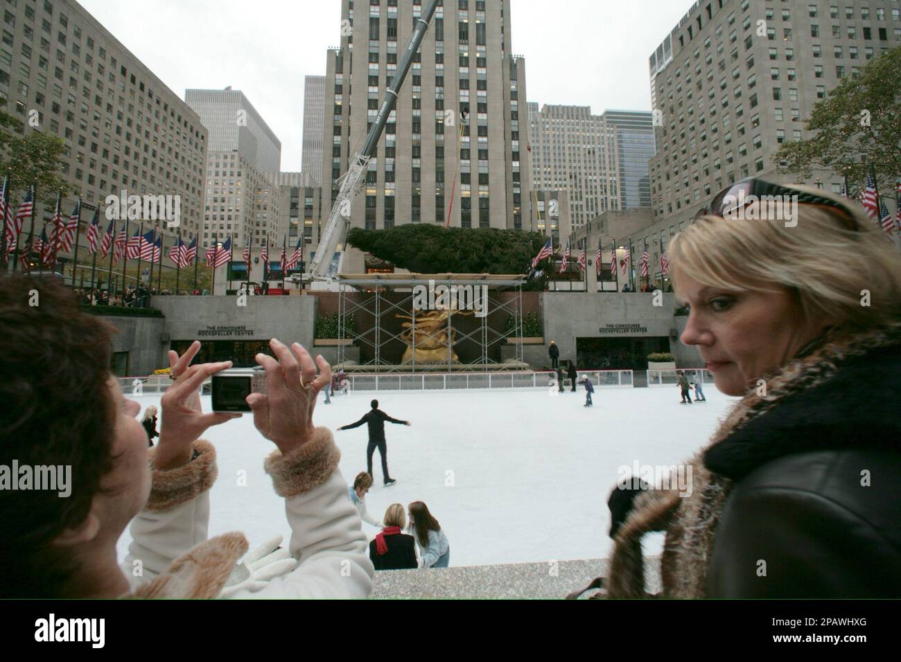 Onlookers snap pictures and watch as a huge crane prepare to hoist an ...
