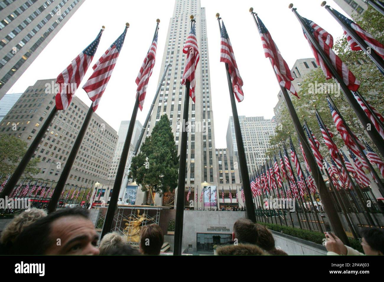 Onlookers watch as a huge crane hoists an 84-foot tall Connecticut ...