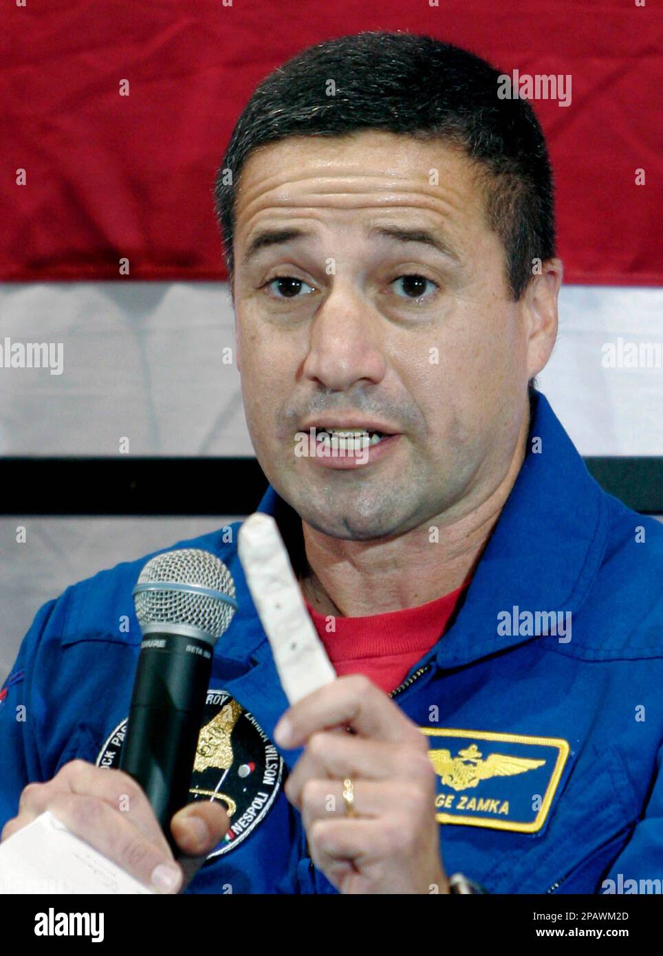 Space shuttle Discovery pilot George Zamka holds up a piece of plastic ...