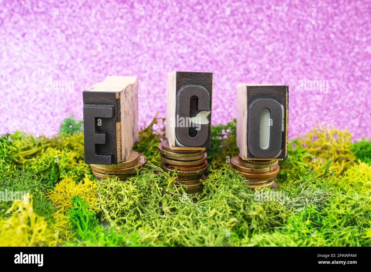 Eco word made with stamp letters on coin stacks, on a moss bed with ...