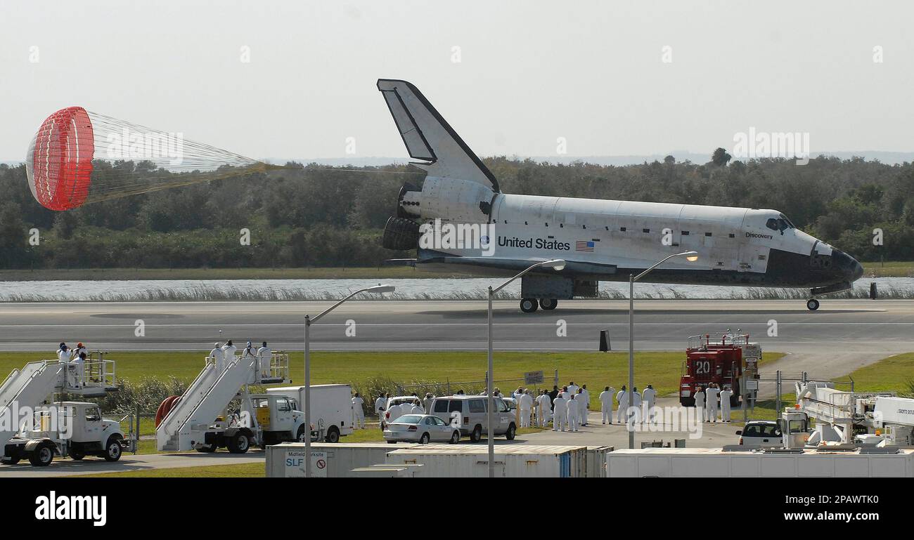 The space shuttle Discovery deploys its braking parachute during ...