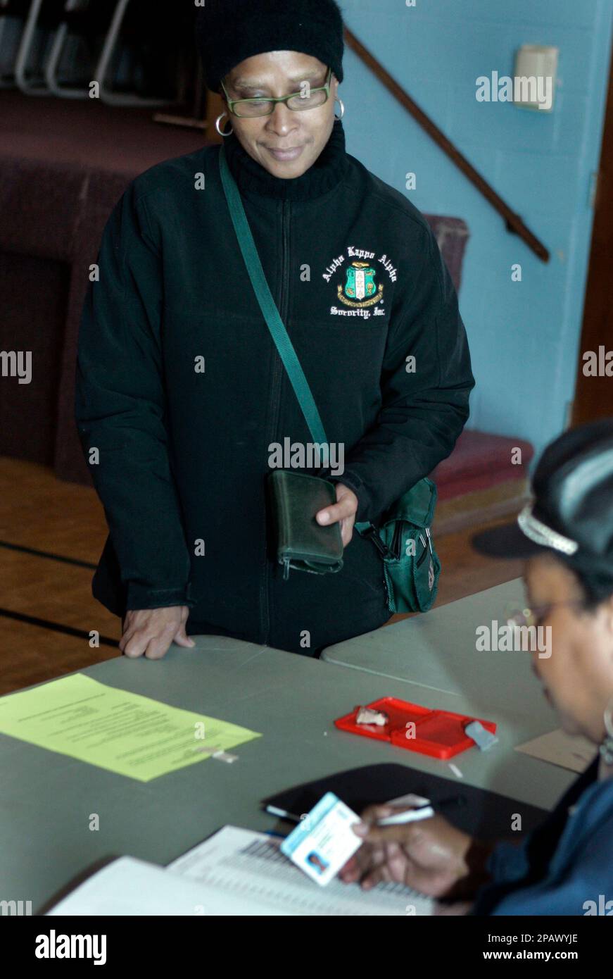 Felecia Hatcher Brown presents her driver's license before voting at ...