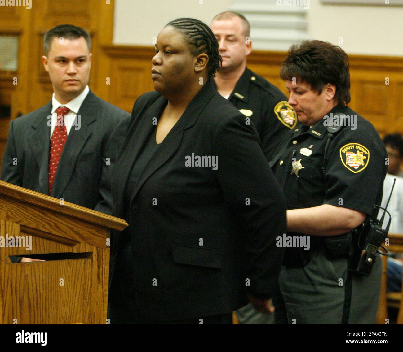 Myisha Ferrell is handcuffed by a deputy sheriff as her attorney, John ...