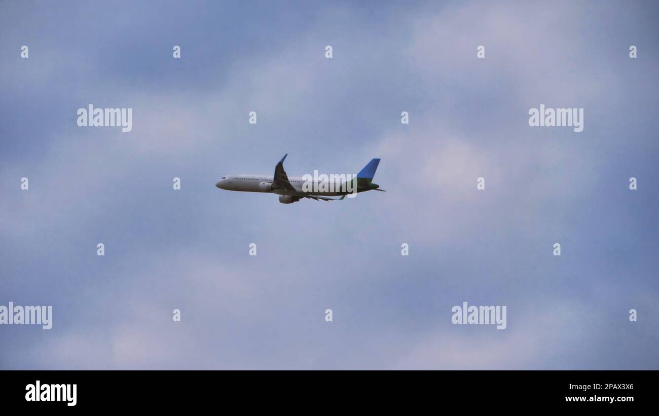 White passenger airplane flying in the sky amazing clouds in the ...