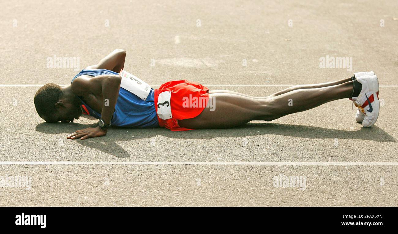 Kenya's Martin Lel lies on the street after crossing the finish line to ...