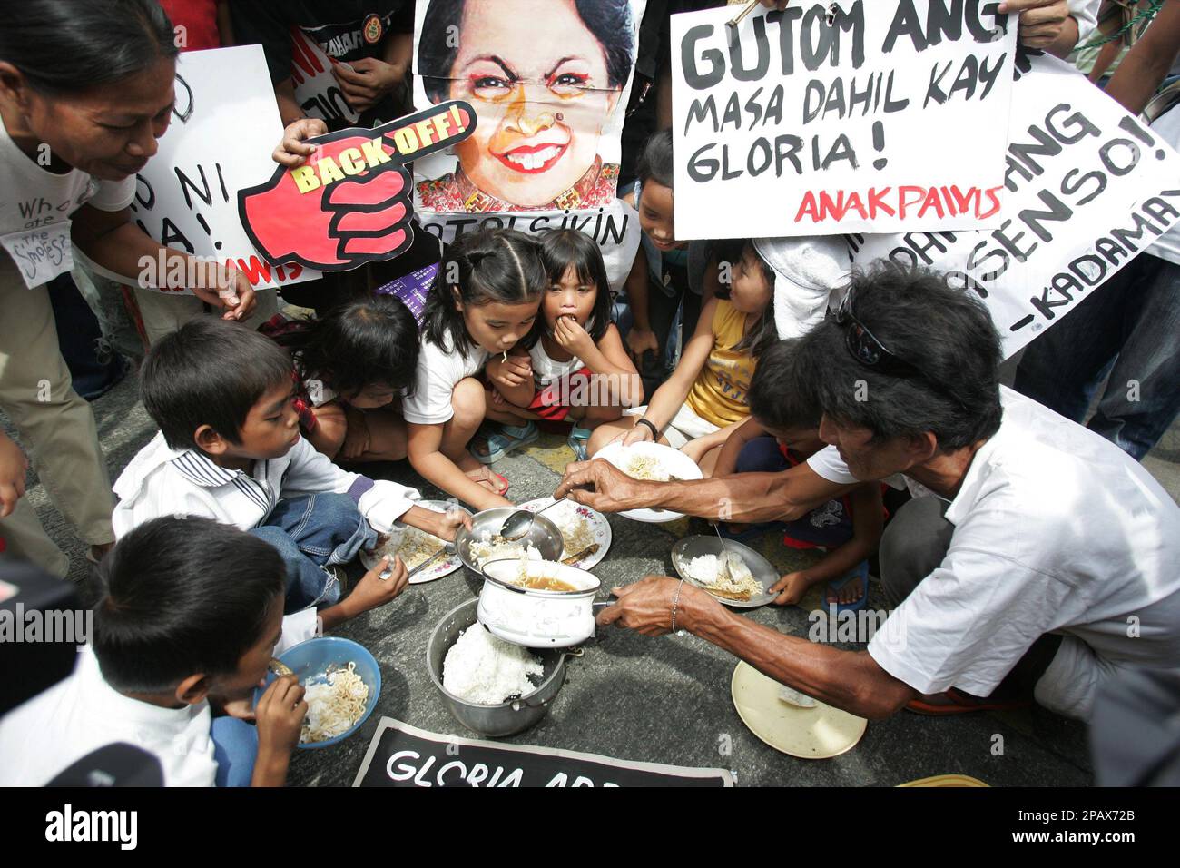 Activists and their children eat a meal consisting of dried fish ...