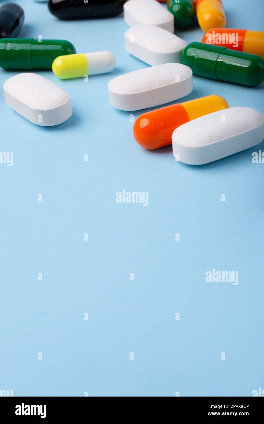 Front view of different pills on blue background,vertical banner with ...