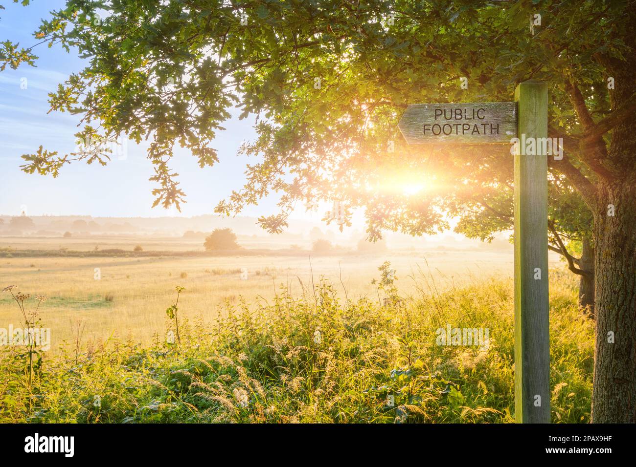 Sunrise on public footpath sign and British countryside background with ...