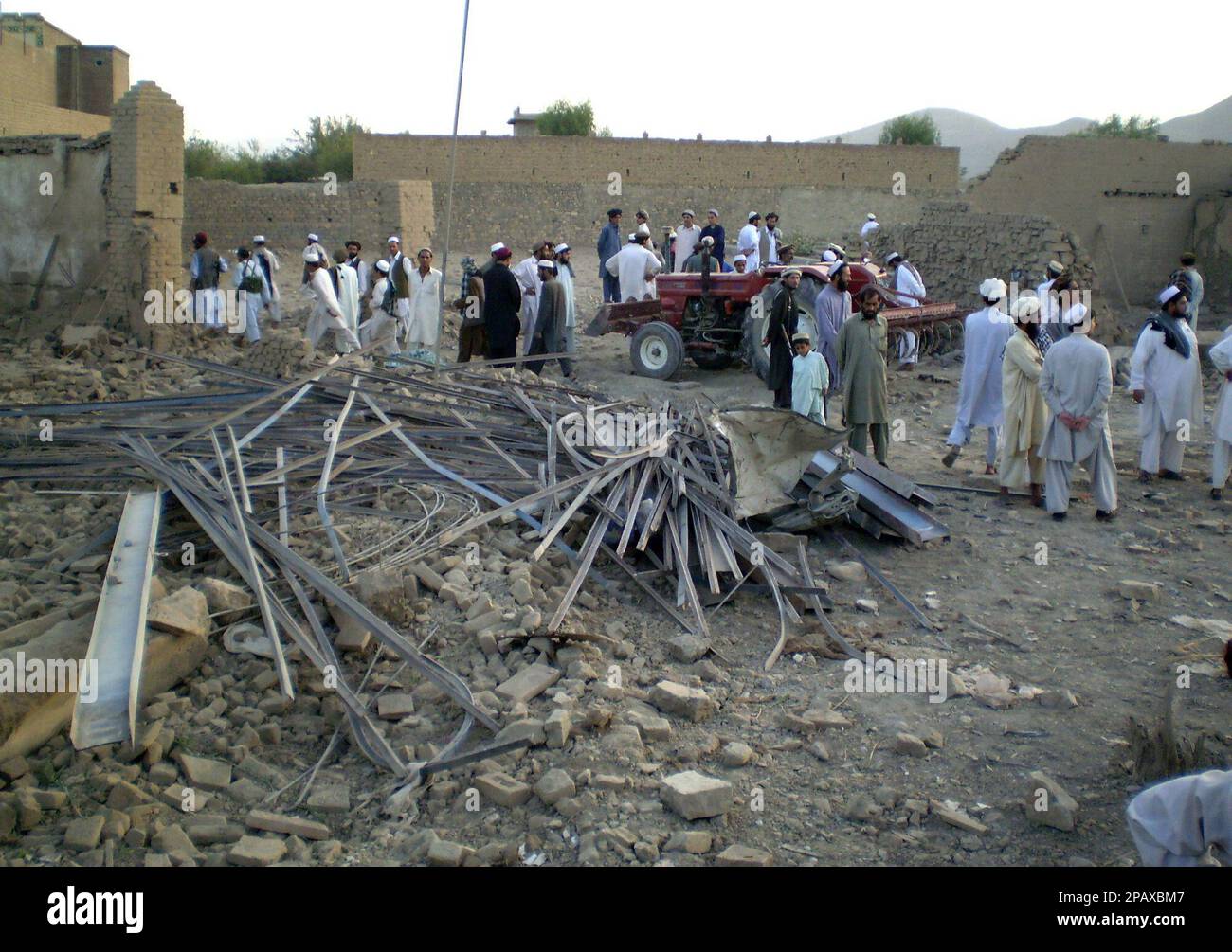 Local tribesmen gather beside the rubble of a house after a missile ...