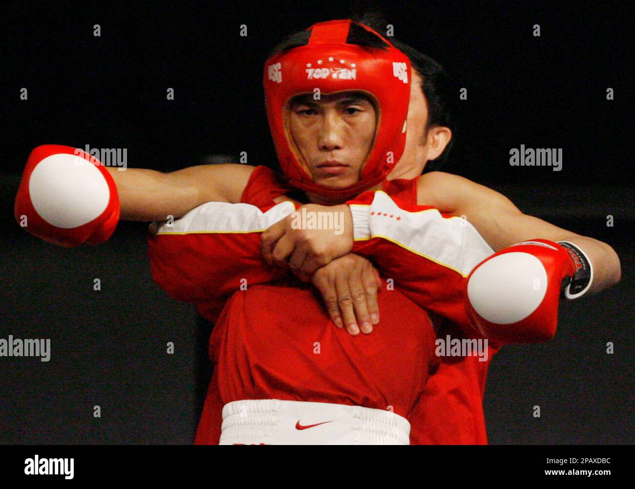 Yu Gu, front, of China, stretches with his coach before his boxing ...