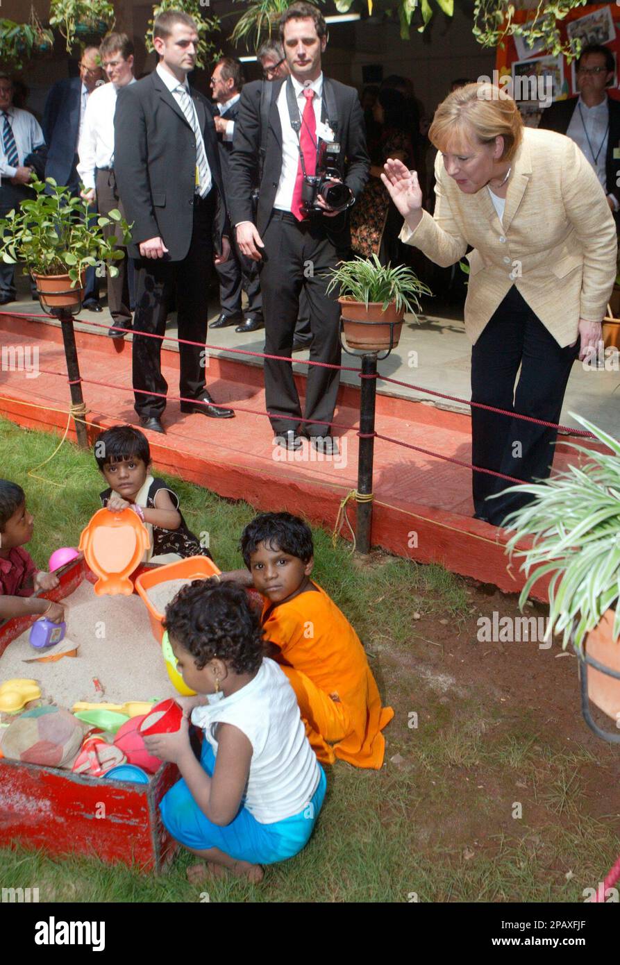 German Chancellor Angela Merkel, right, greets children during their ...