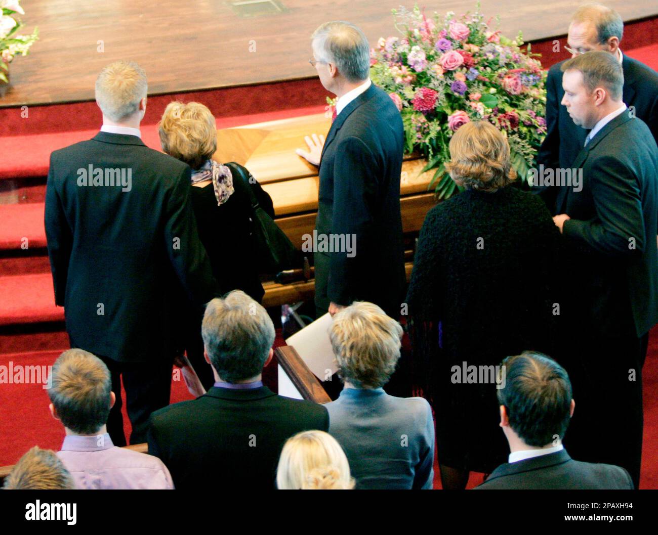 The Rev. Rolf Olson, center, touches the casket of his daughter as he ...