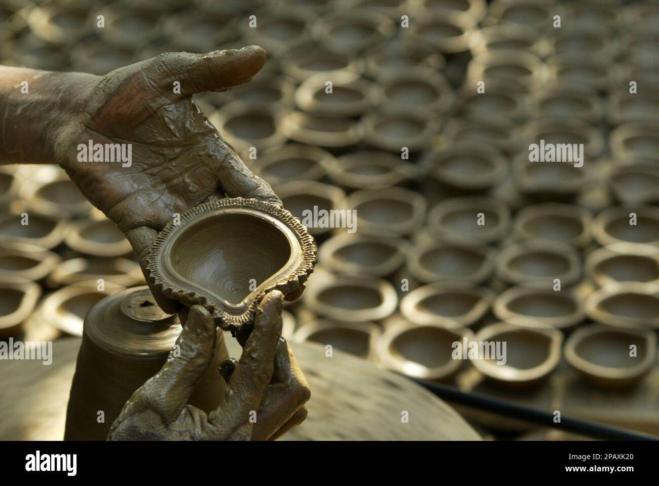 An artist makes earthen lamps for the upcoming Diwali festival in Jammu ...