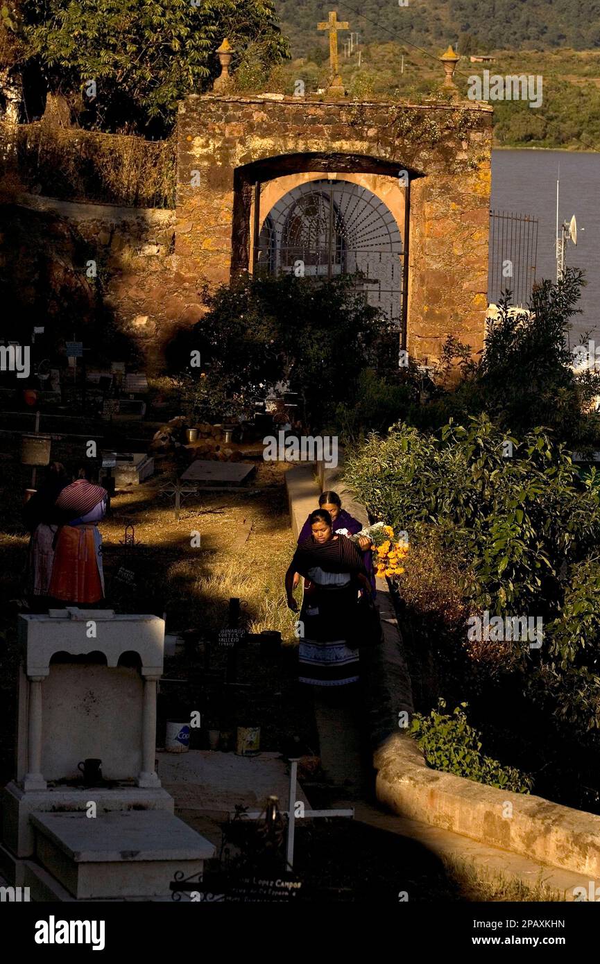 Women walk by the Janitzio Island cemetery, in Janitzio, Mexico ...