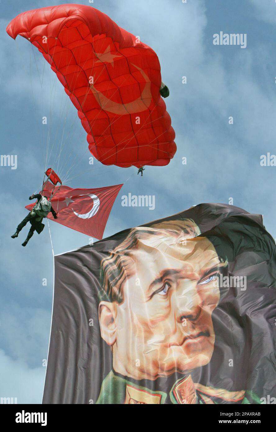Turkish army parachutists perform with a national flag and a portrait ...