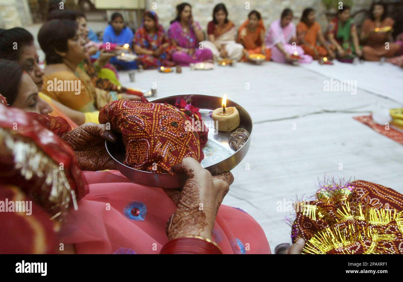 A married Hindu women holds a plate containing ritual materials as she ...