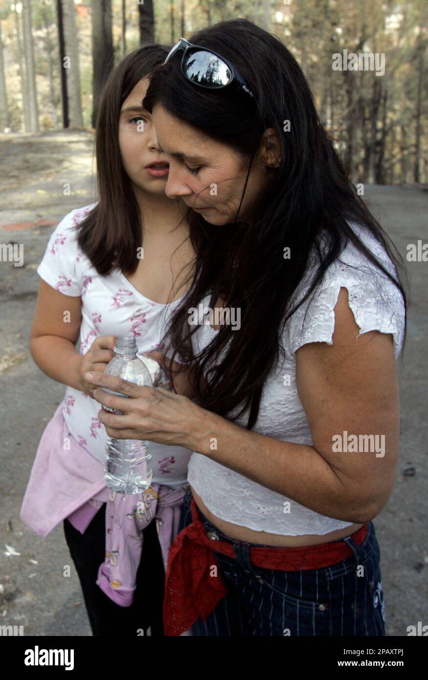 Janet Knecht, right, and daughter Katie Knecht react after visiting the remains of their home in ...