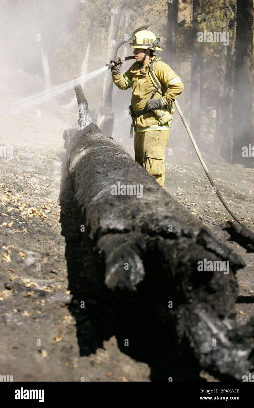 San Bernardino County firefighter Carlos Munoz hoses down hotspots left ...