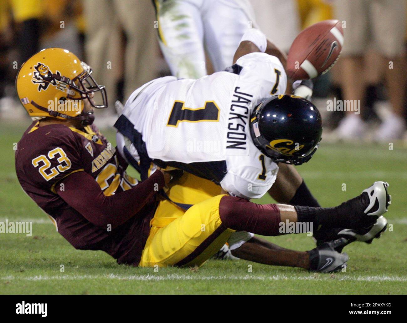 California punt returner DeSean Jackson, top, fumbles the ball as he is ...