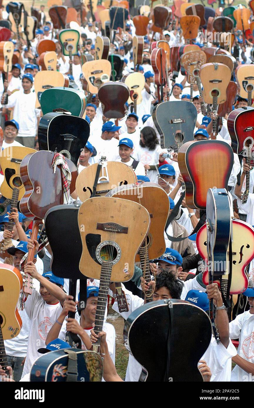 Participants lift their guitars after an attempt for a new Guinness ...