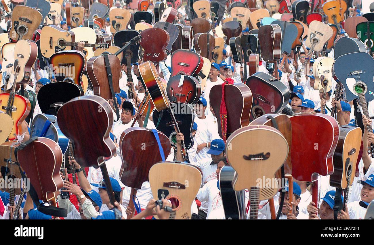 Participants lift their guitars after an attempt for a new Guinness ...