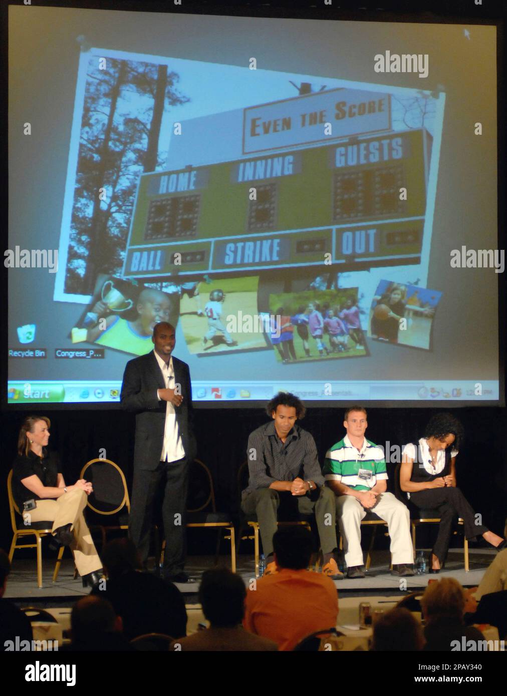Athlete Alvin Harrison, second from left, stands to tell attendants of ...