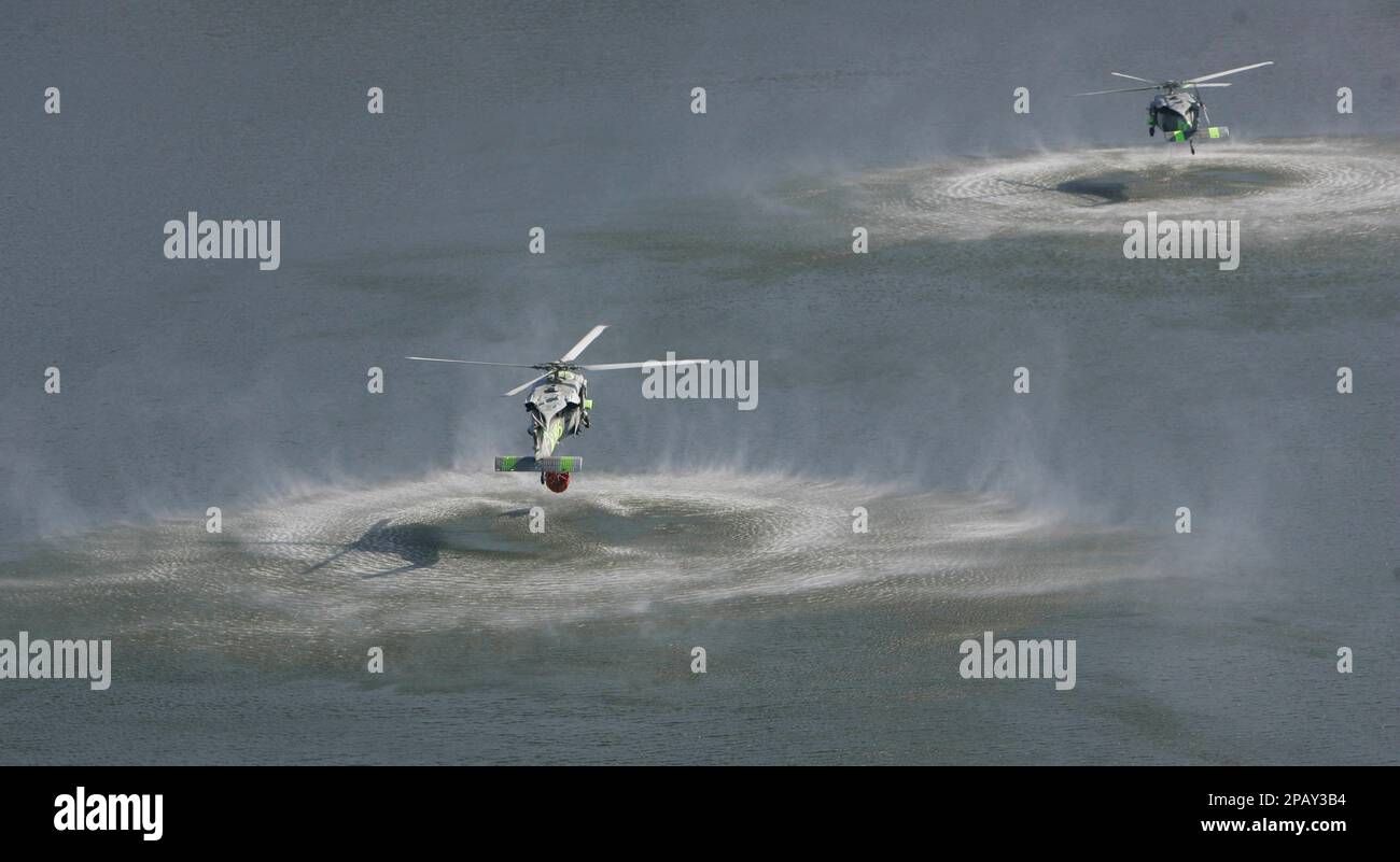 Navy MH-60S helicopters fill their water bladders to make drops on the ...