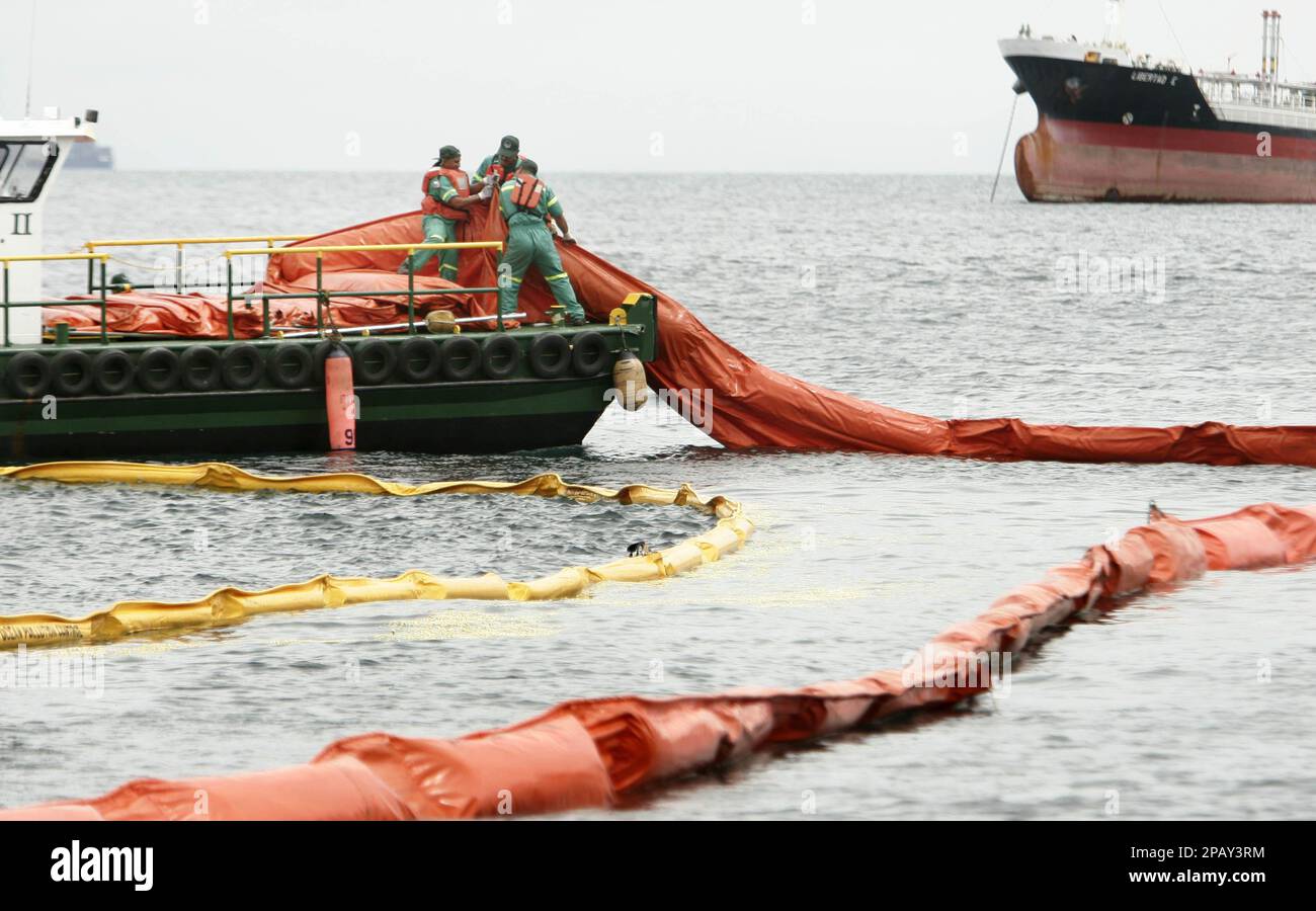 Volunteers set up absorbent booms used to soak up oil during a practice ...