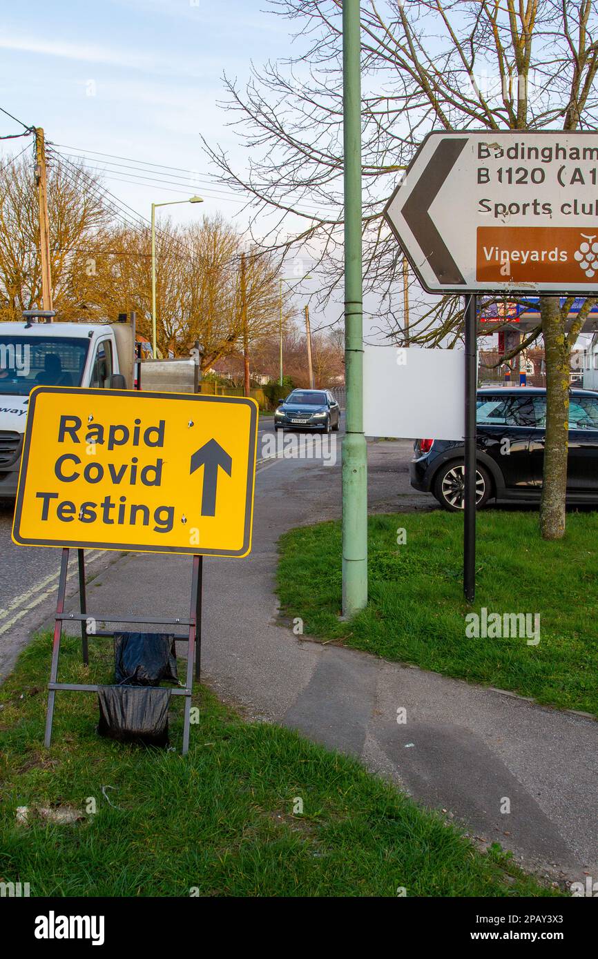 Temporary yellow roadside sign with direction arrow to rapid covid ...
