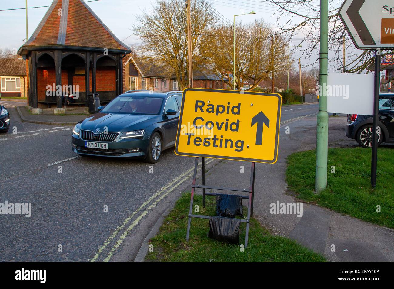 Temporary yellow roadside sign with direction arrow to rapid covid ...