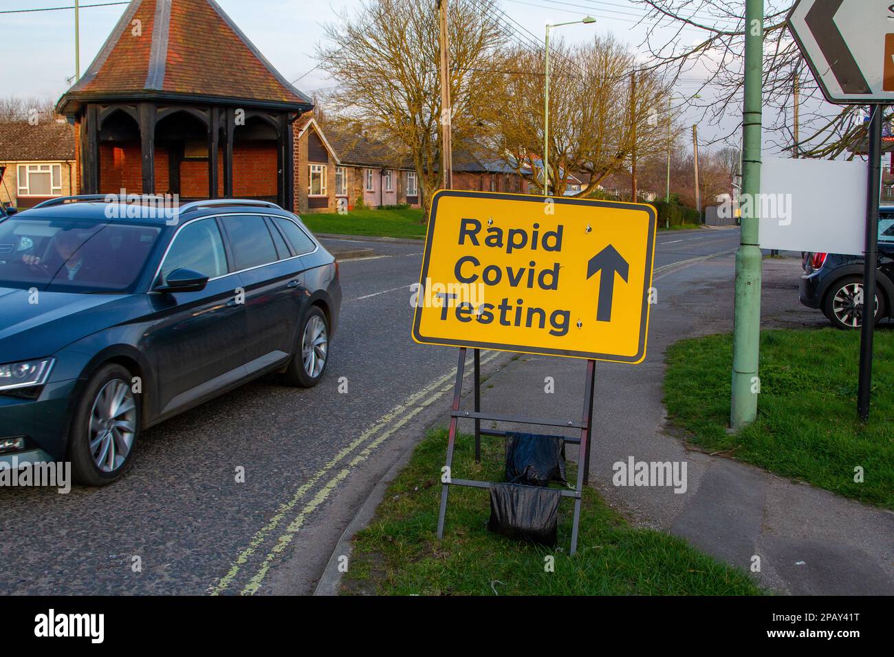 Temporary yellow roadside sign with direction arrow to rapid covid ...