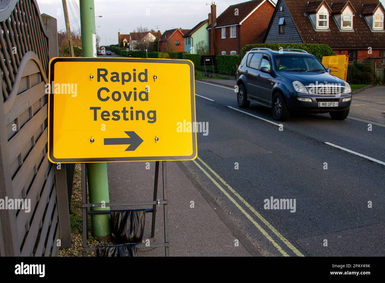 Temporary yellow roadside sign with direction arrow to rapid covid ...